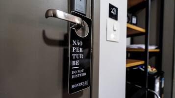 Porta de hotel com uma placa que diz 'NÃO PER TUR BE DO NOT DISTURB' e 'MONREALE HOTELS'.