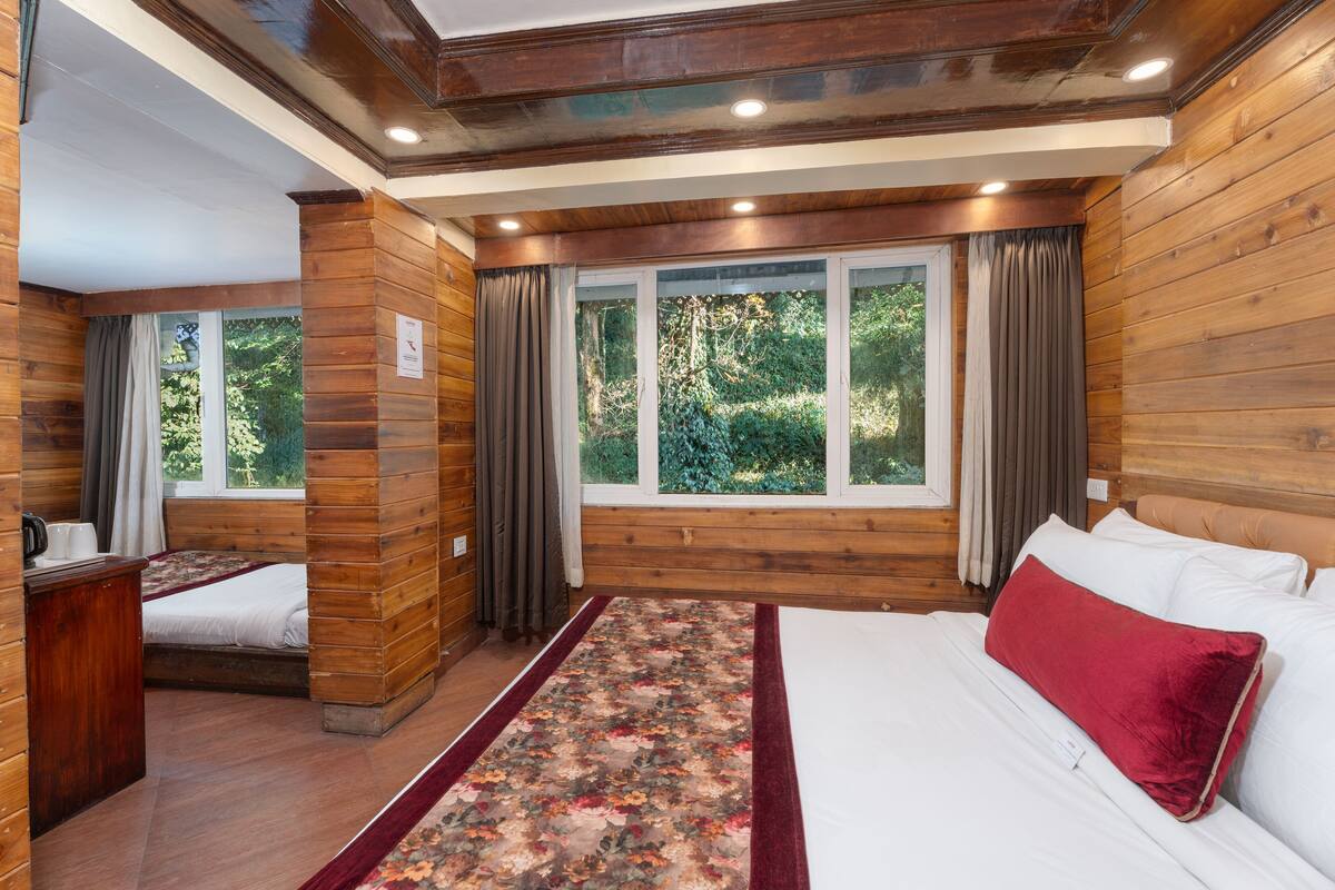 Um quarto com painéis de madeira, uma cama, uma escrivaninha e uma janela com cortinas.