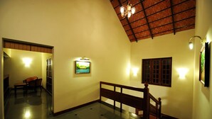 Um corredor com um banco de madeira, uma escada e um quadro na parede.