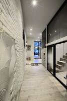Um interior moderno com uma parede de tijolos, uma escadaria e vista para outro espaço.