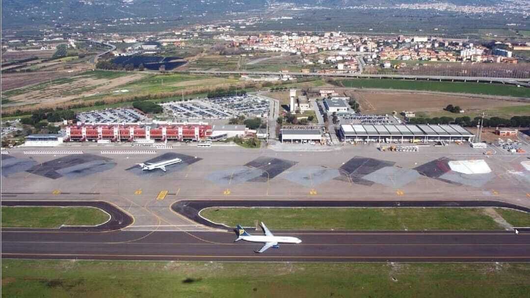 Um aeroporto com várias pistas, um edifício terminal e aeronaves estacionadas.