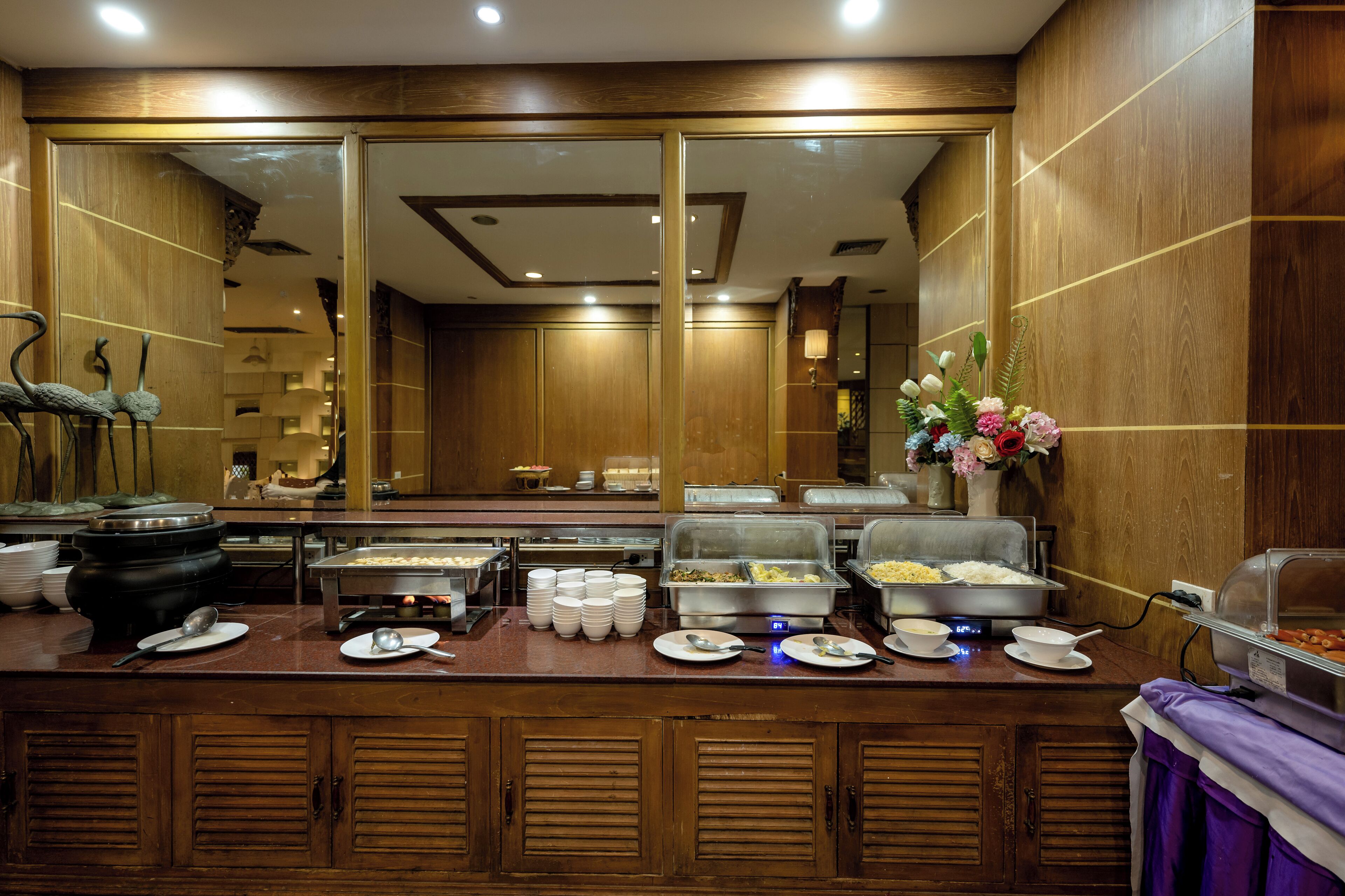 Disposição de buffet com vários recipientes de comida e utensílios.