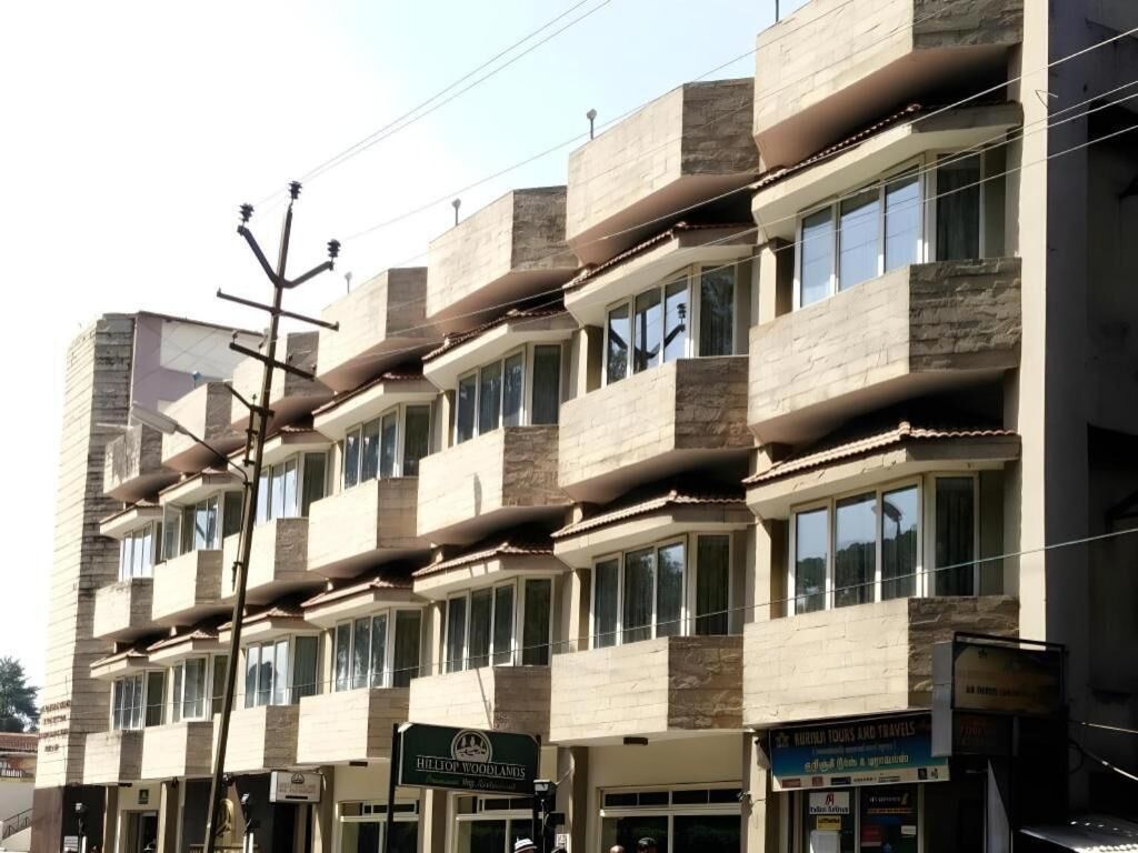 Um edifício de vários andares com uma série de varandas, uma placa com 'Hotel Dominos' e uma placa com 'Nakhchivan Tours and Travels'.