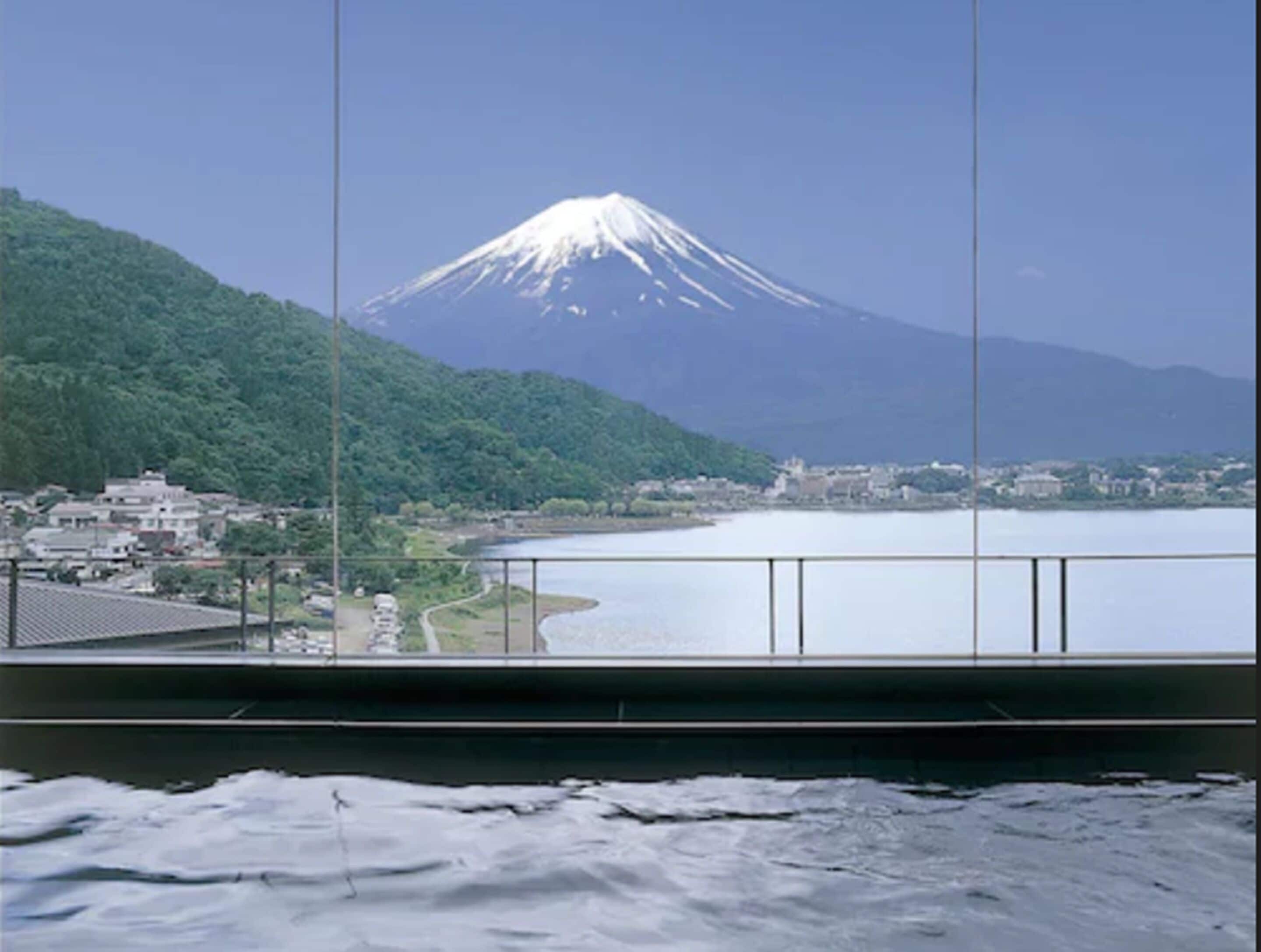Vista do Monte Fuji, com uma cidade e um lago ao primeiro plano.