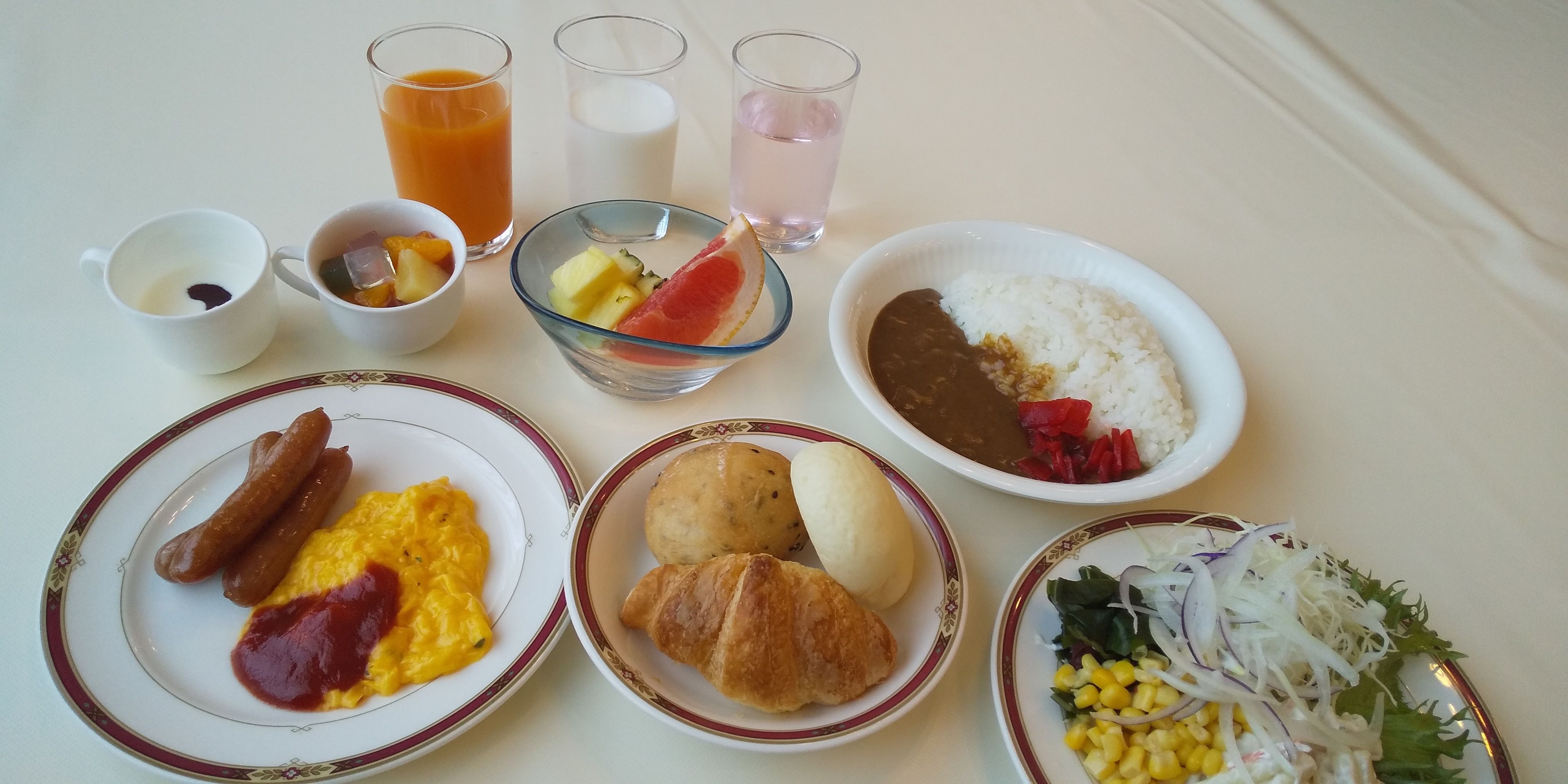 Uma mesa farta com diversos pratos e bebidas para o pequeno-almoço.