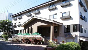 Um hotel com vários andares, varandas, área de estar ao ar livre e céu claro.