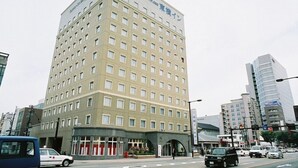 Um hotel de vários andares com design moderno, destacando uma entrada imponente e um grande número de janelas.