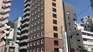 Um hotel de vários andares com fachada marrom, várias janelas e varandas.