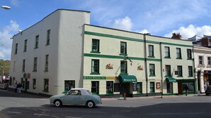 Um edifício com fachada verde e branca, exibindo o Royal Britannia Inn e um restaurante próximo.