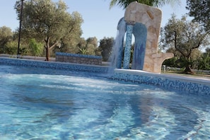 Piscina exterior, uma piscina com cascata, guarda-sóis 