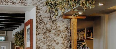 Uma área de bar com banquetas de madeira e balcão.