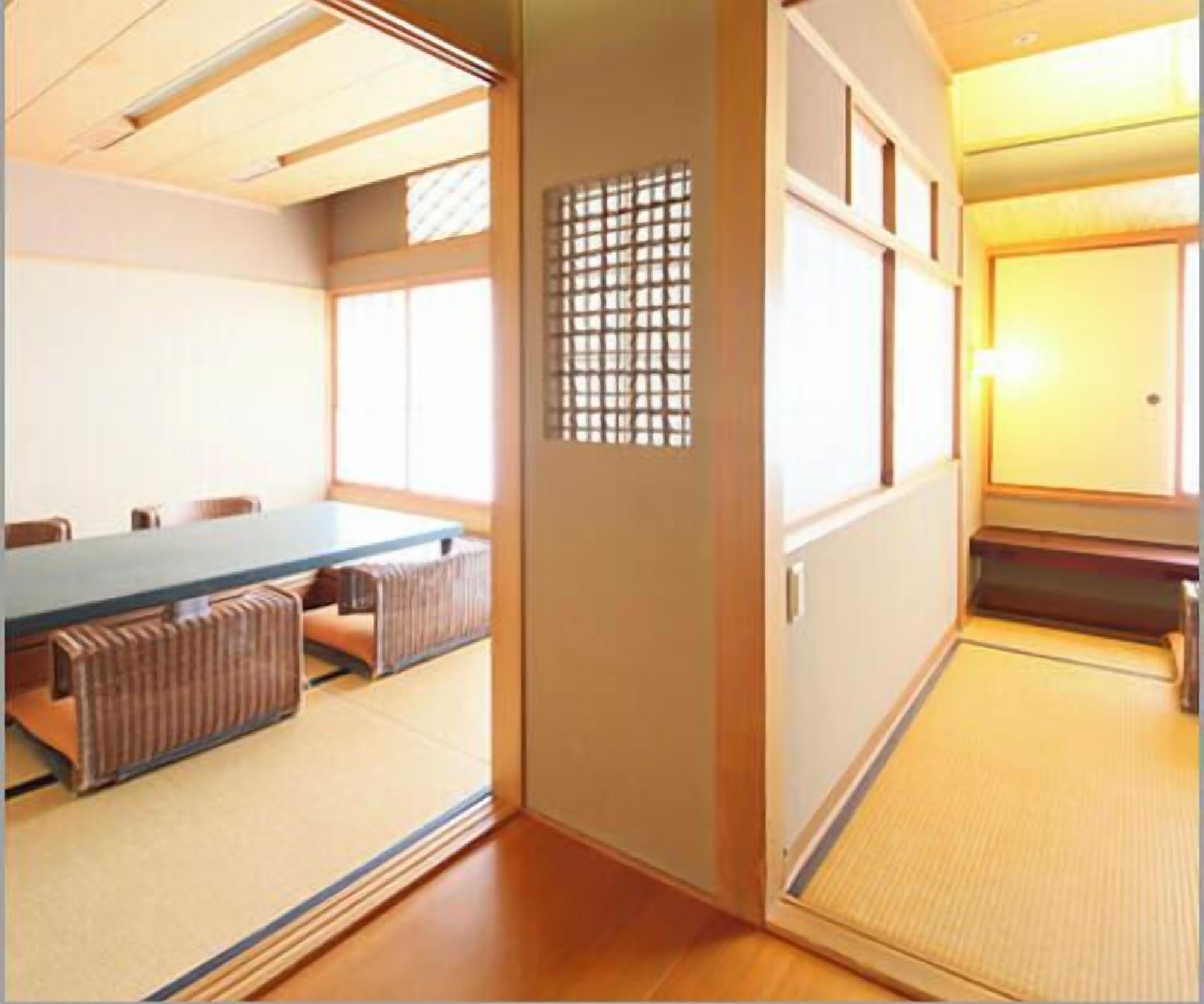 Um quarto japonês tradicional, com tatames, uma mesa baixa e portas deslizantes.