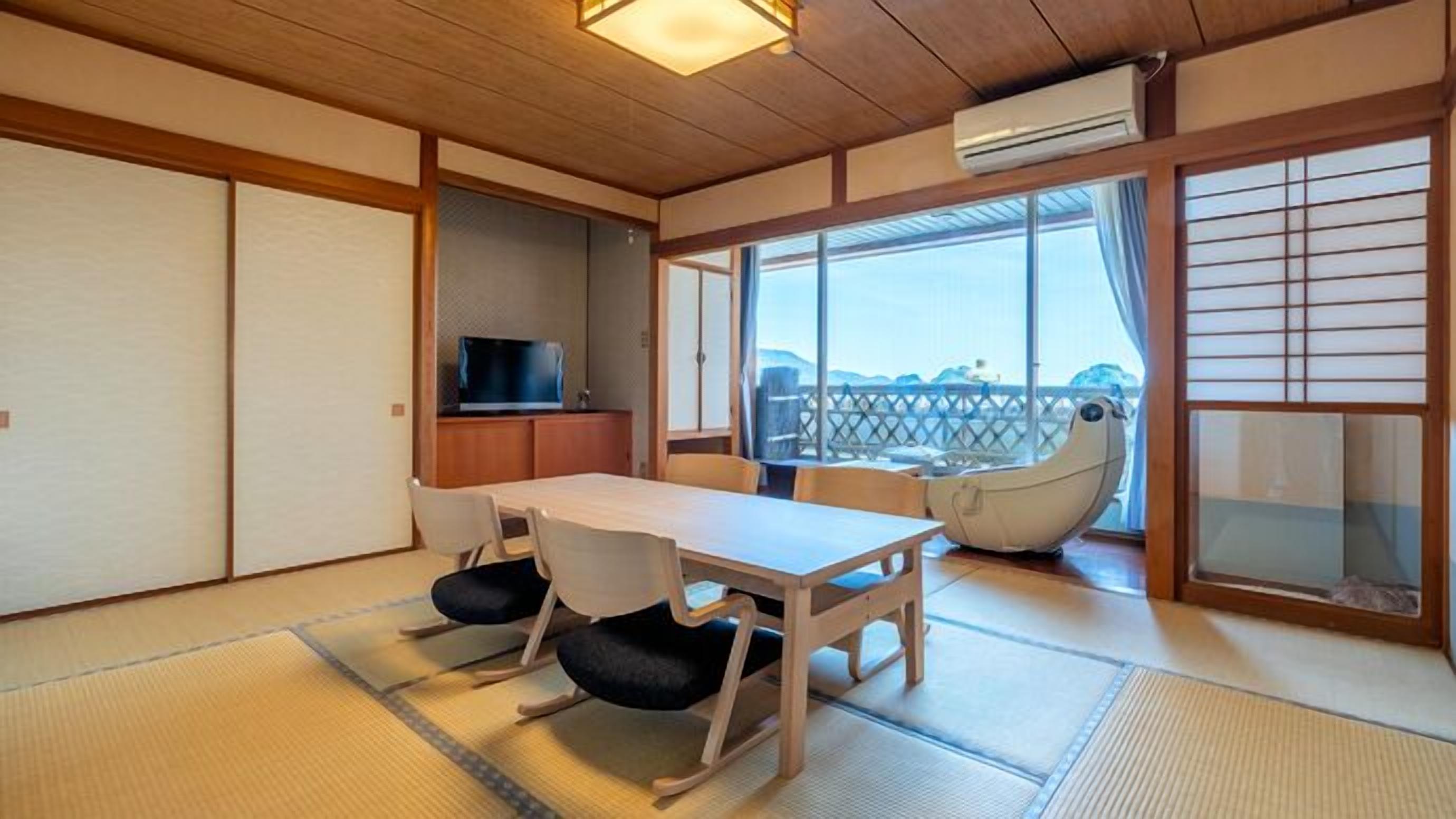 Um quarto em estilo japonês tradicional com tatames, uma mesa baixa com cadeiras, uma televisão e uma varanda com vista.