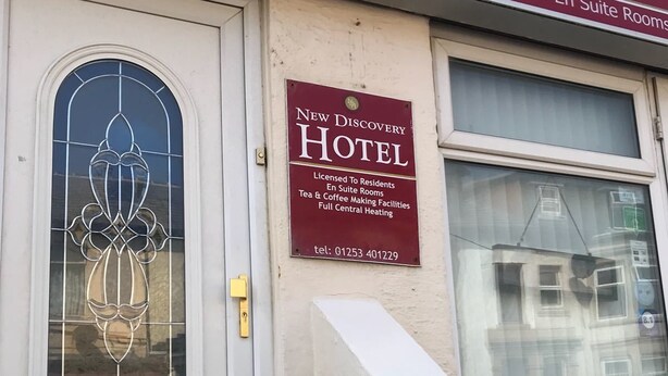 Placa de hotel com vitrais e um número de contato.