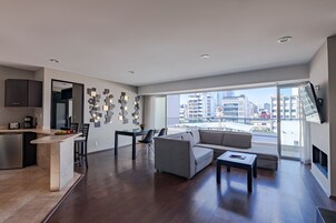 Um espaço moderno para relaxar com cozinha, sala de jantar e área de estar, com vista para a cidade.