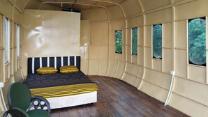 Um quarto com cama, cadeira e janela.