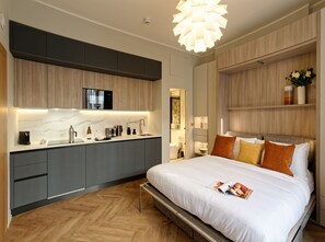 Quarto moderno com cama grande, mesas de cabeceira e guarda-roupa embutido.