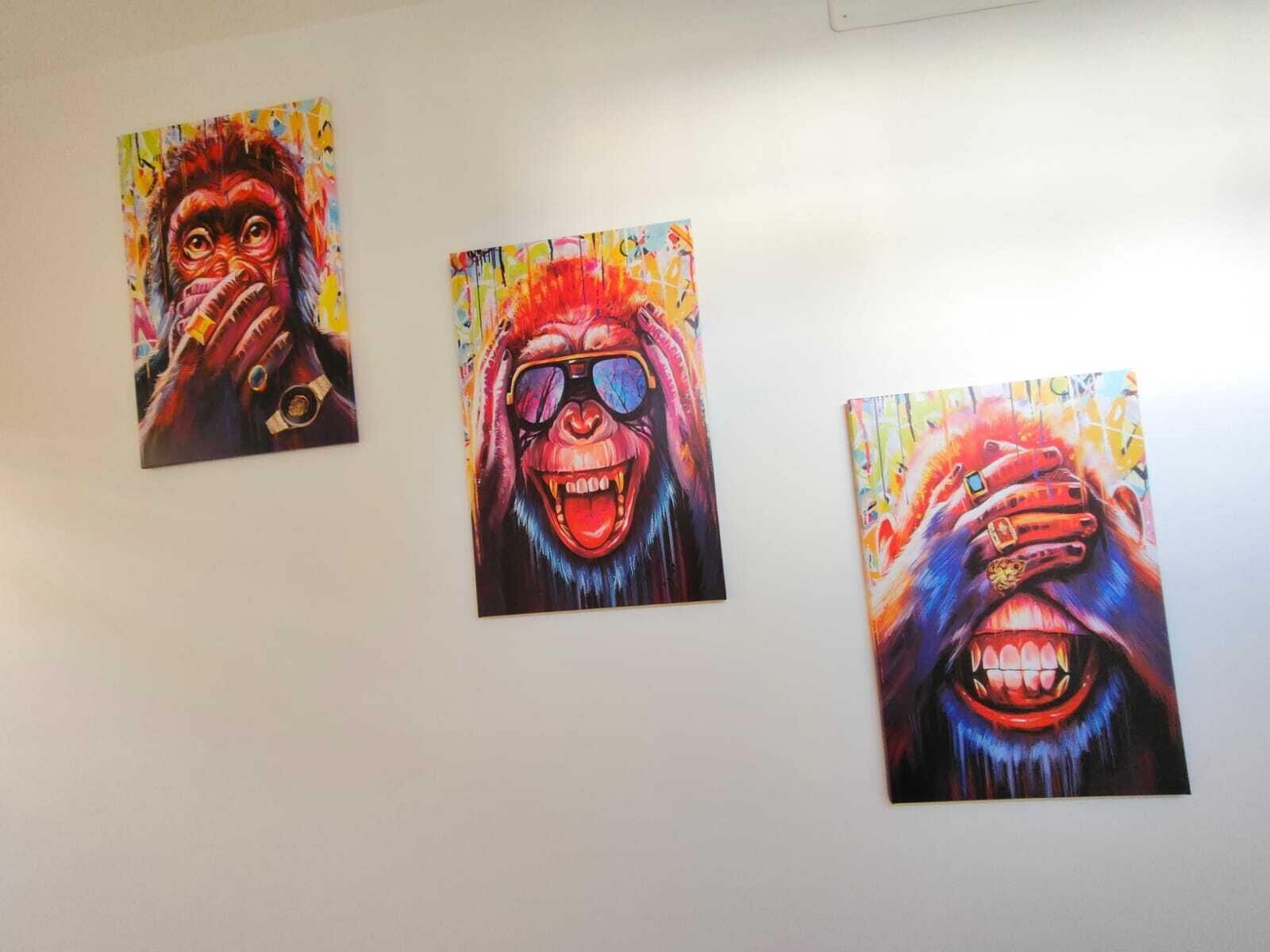 Três quadros numa parede lisa.