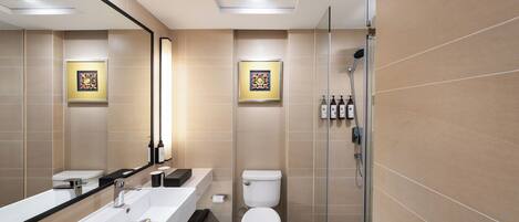 Uma casa de banho moderna com um espelho grande, uma banheira, uma sanita e um chuveiro.