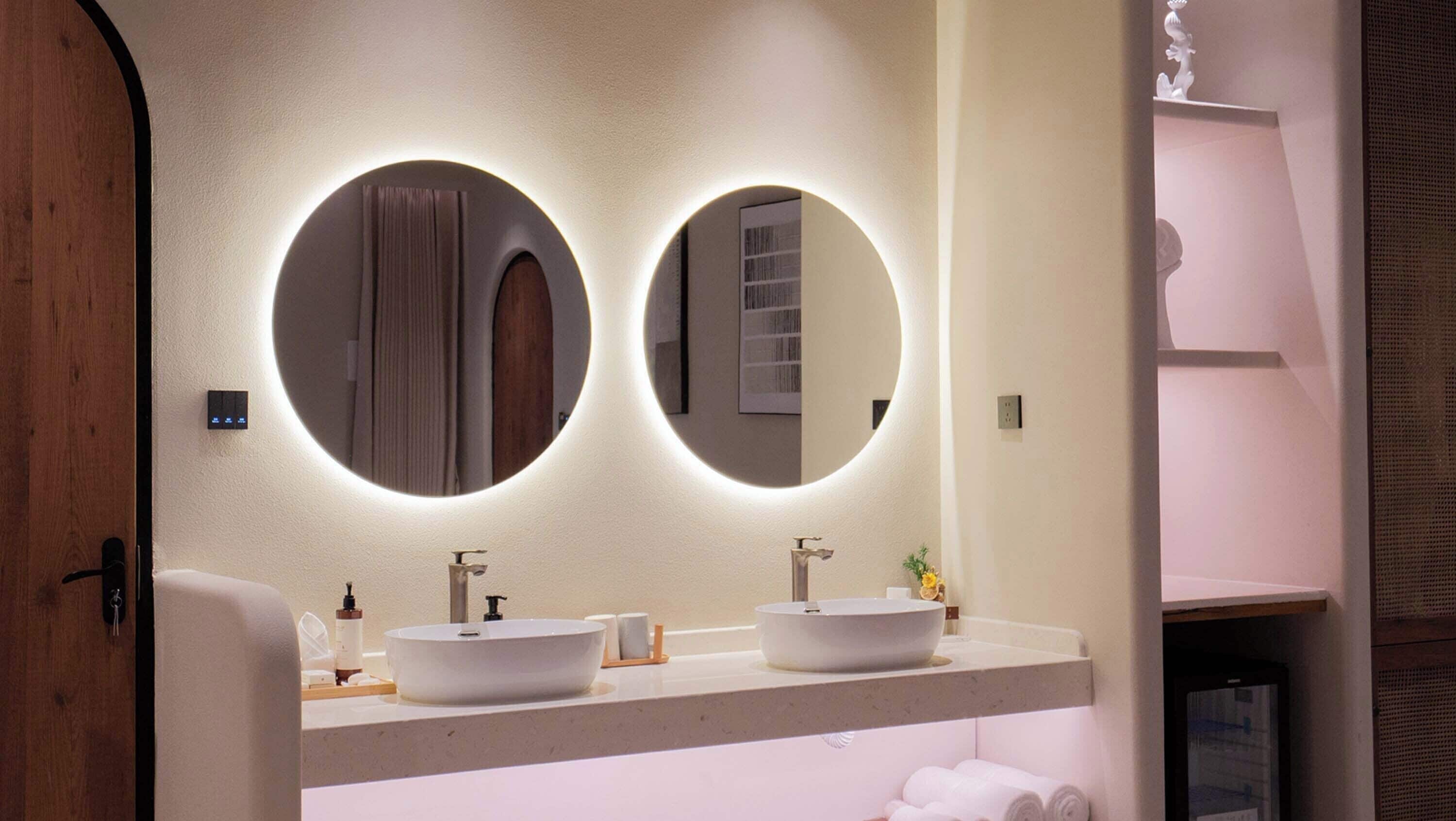 Casa de banho moderna com duas bacias, espelho e suporte para toalhas.