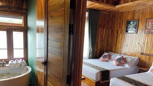 Quarto de madeira com banheira, duas camas e uma janela.