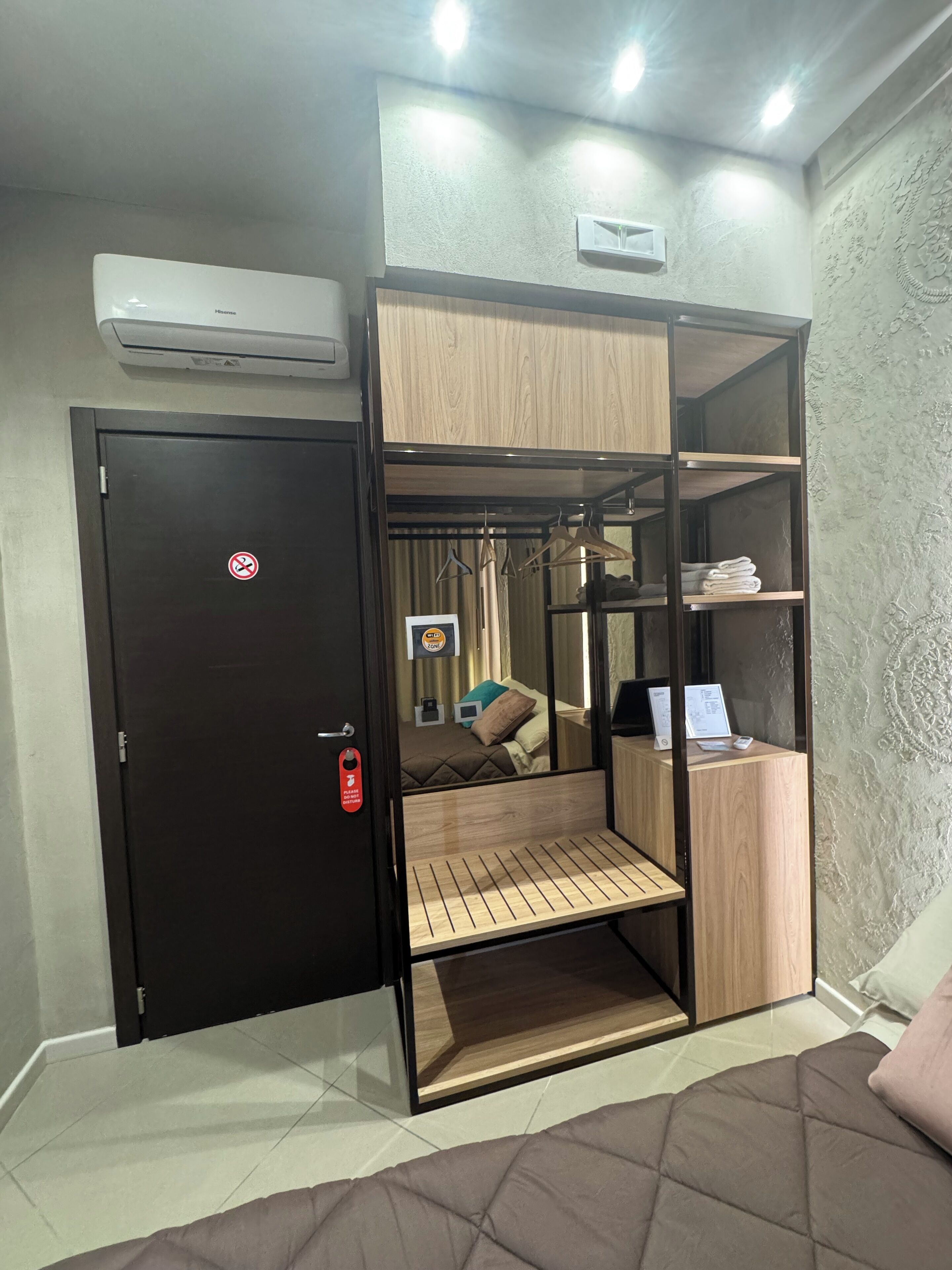 Quarto compacto com guarda-roupa, cama, escrivaninha e cabideiro.