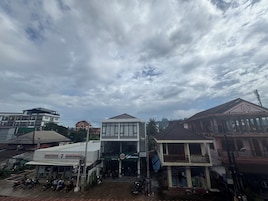 Uma loja de conveniência 7-Eleven com café no interior, rodeada por edifícios altos.