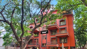 Um edifício vermelho com varandas e uma placa com a inscrição 'Townhouse Oak'.