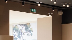 Um interior moderno com uma escada que leva a uma varanda com vista para a água.