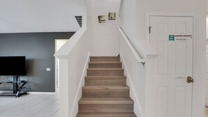 Uma escadaria com uma porta branca identificada com a placa "Crofton Paradise" e um sinal de WiFi.