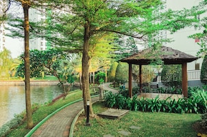 Um parque tranquilo com um lago, um coreto e um caminho.