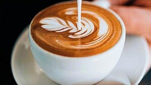 Uma chávena de café com arte de latte num pires.