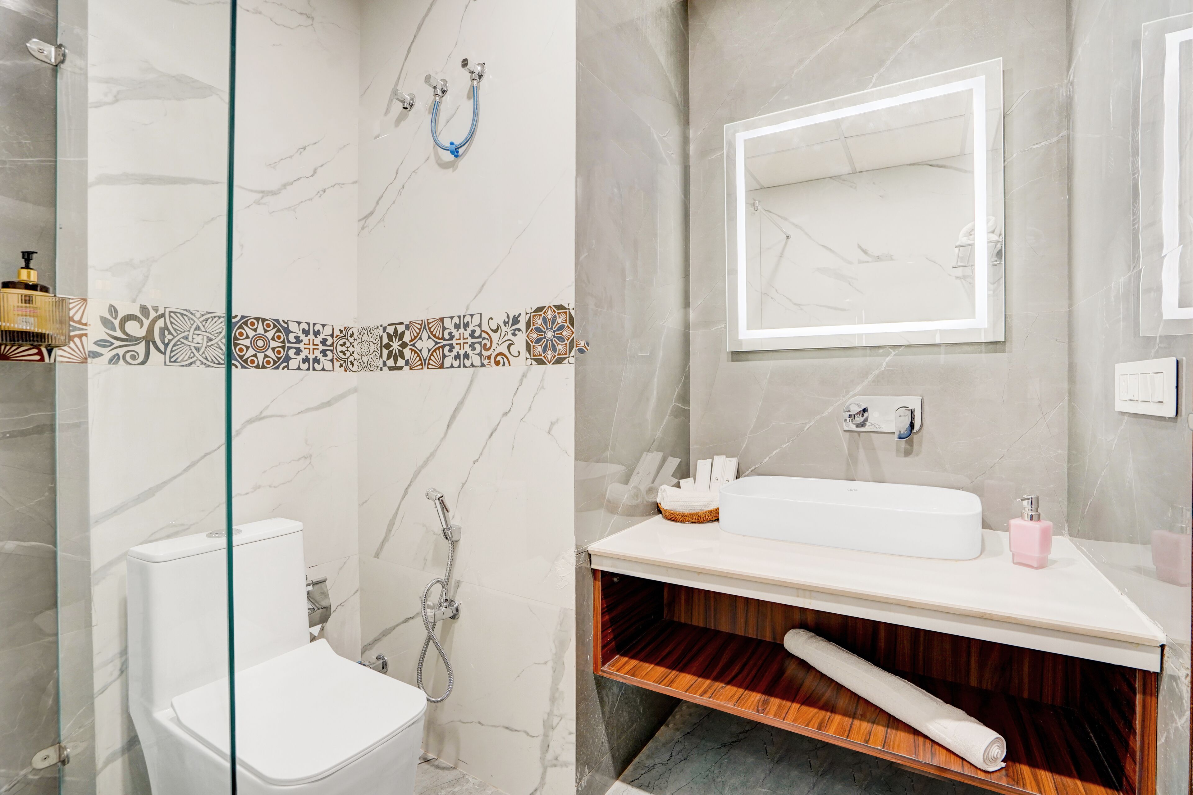 Uma casa de banho moderna com sanita, chuveiro e lavatório.
