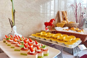 Buffet com diversos doces, incluindo bolos em camadas e tartes.