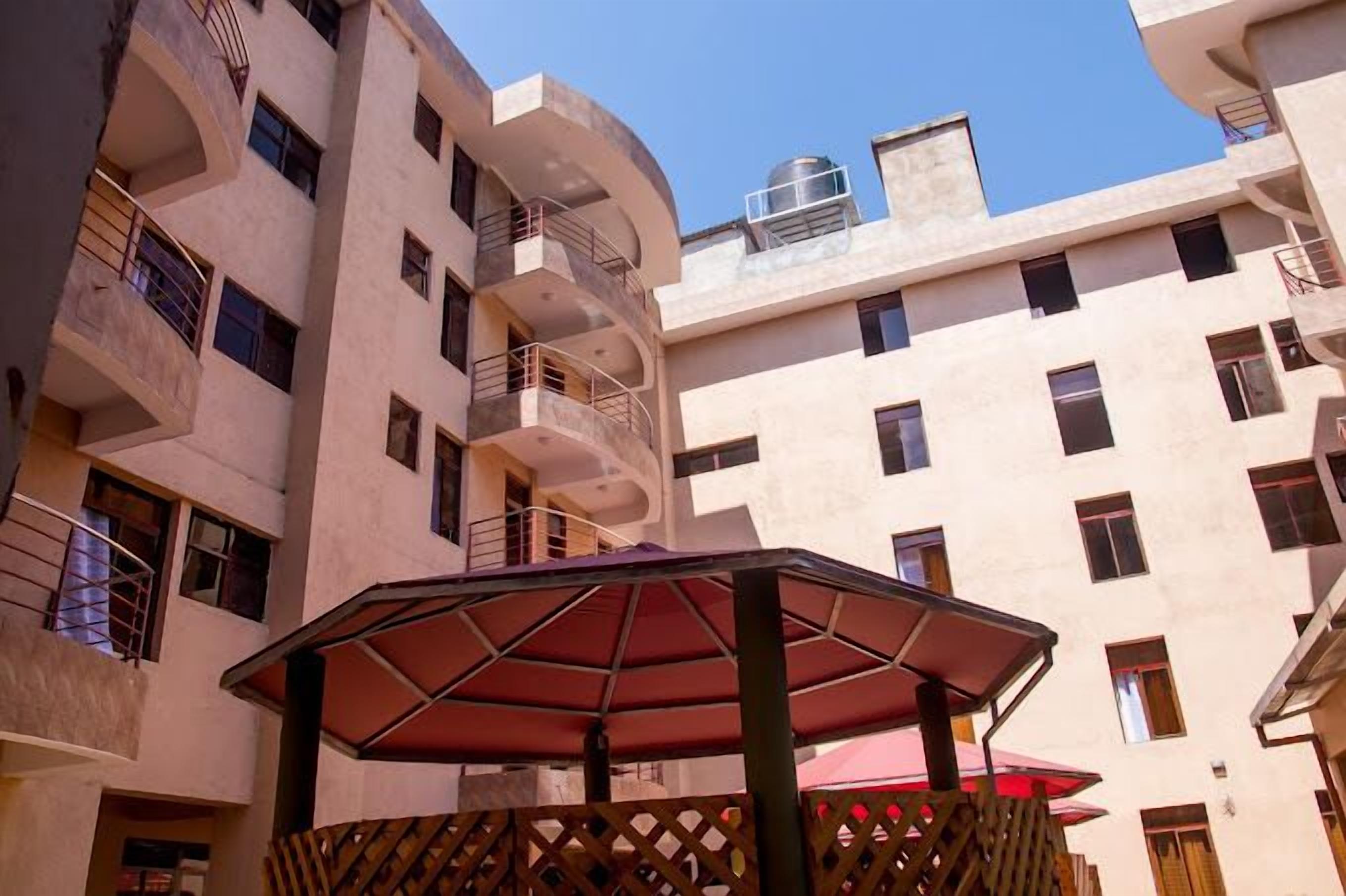 Um edifício de vários andares com varandas e uma área de estar coberta ao ar livre.