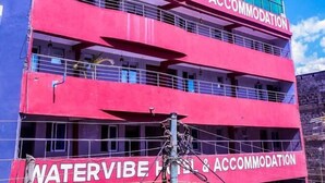Um hotel com vários andares, com placas indicando que é um hotel e oferece acomodação.