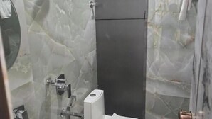 Um banheiro com vaso sanitário, bidê e chuveiro.