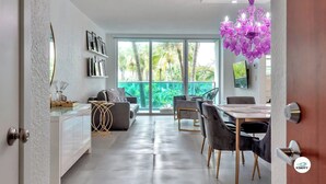 Uma sala de jantar moderna com vista para um jardim exuberante através de grandes janelas.
