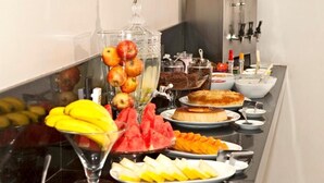 Buffet com diversas frutas, sobremesas e bebidas.