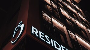 Um edifício com letreiros iluminados que dizem "RESIDENCES".
