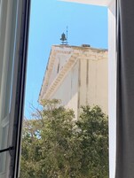 Um edifício com uma torre de sino e um céu azul claro.