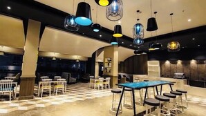 Um interior moderno com área de bar, assentos e iluminação pendente.