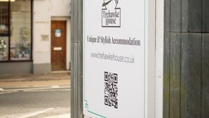 Placa de identificação do Trehawke House, um alojamento único e elegante, com código QR para mais informações.