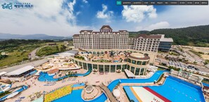 Um hotel grande com várias piscinas, um pátio central e diversas comodidades.