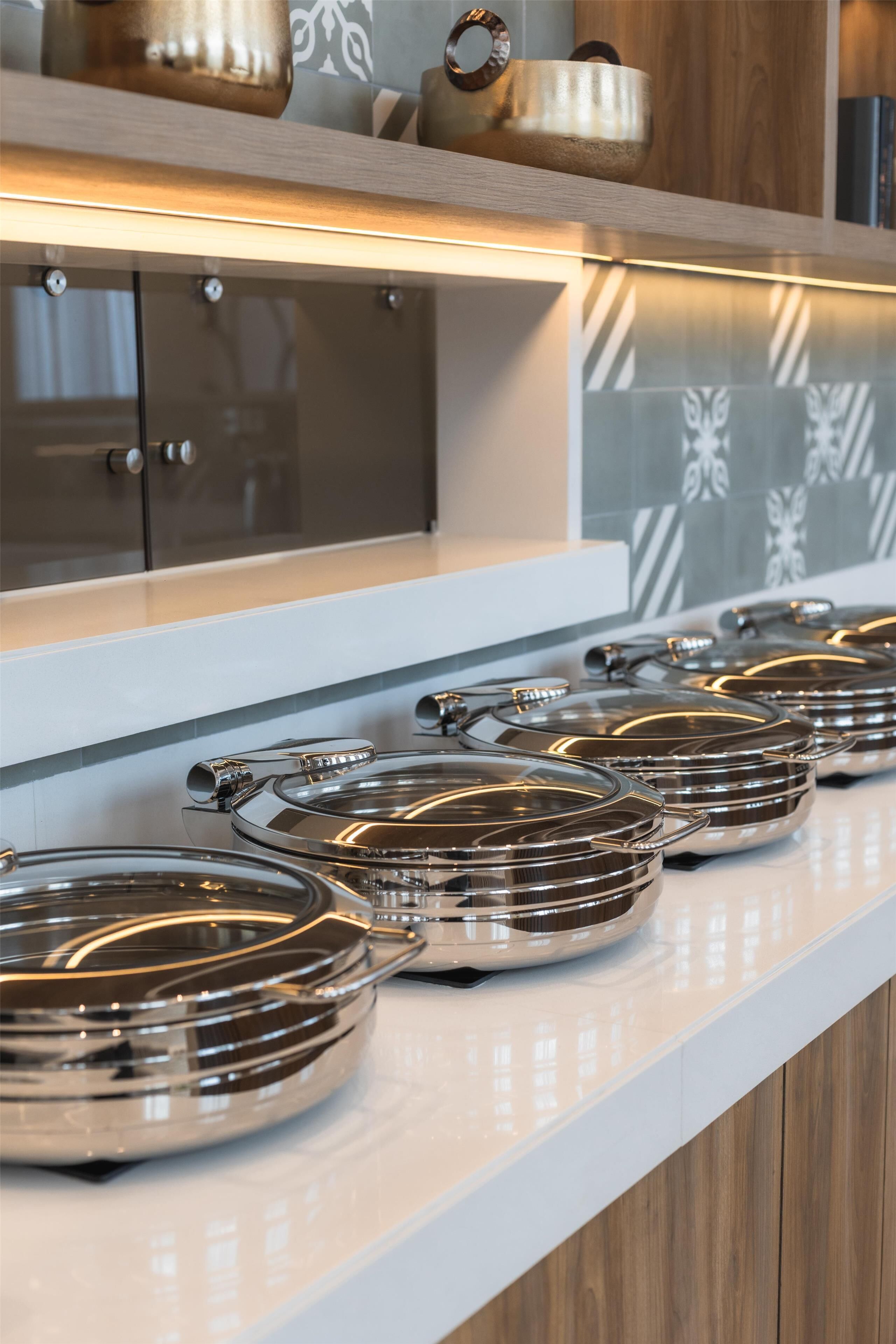Uma bancada de cozinha com travessas de aço inoxidável e design moderno.