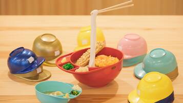 Uma mesa com diversos alimentos e tigelas coloridas, algumas com tampas.