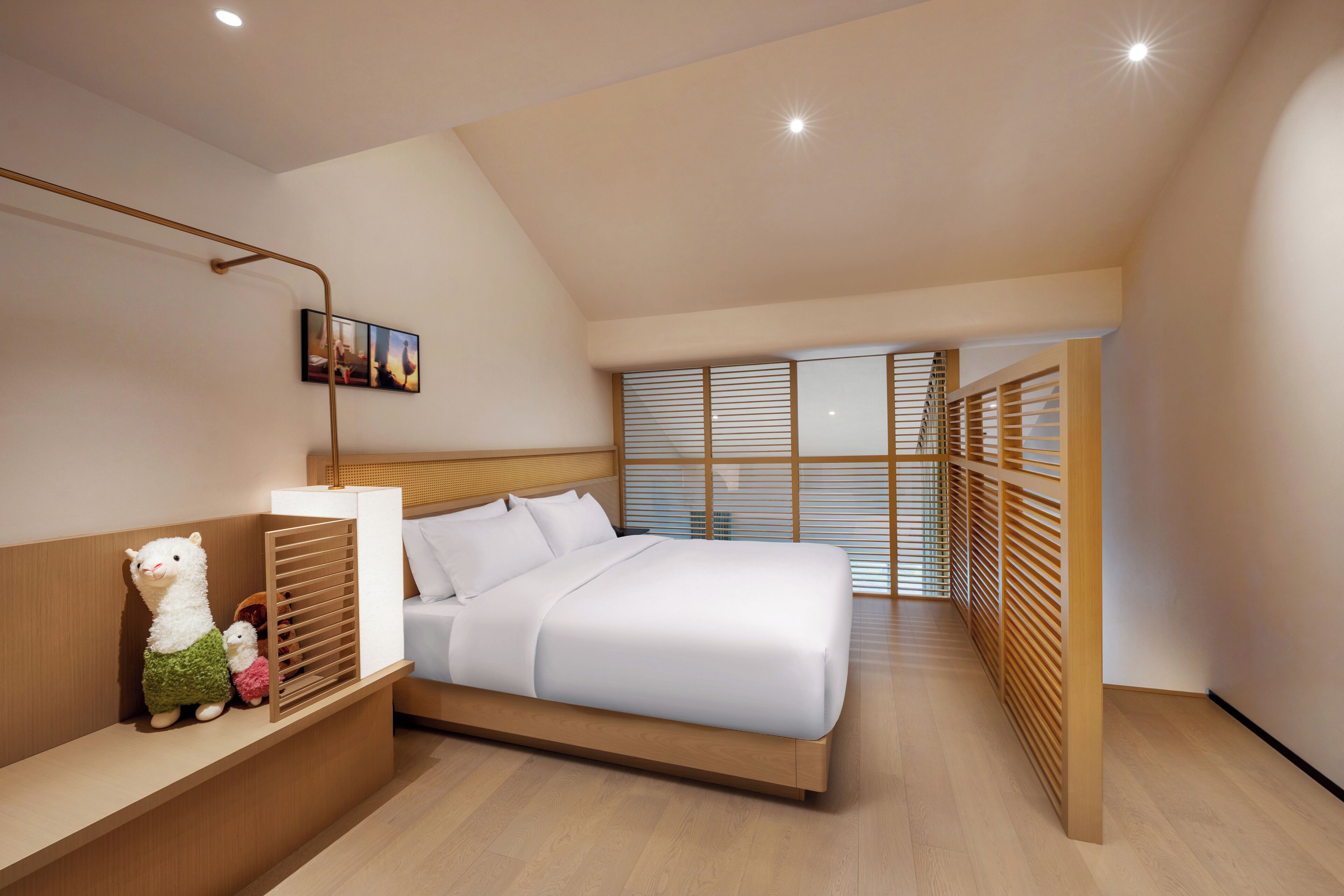 Quarto moderno com cama, mesa de cabeceira, luminária e quadro na parede.