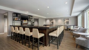 Uma cozinha moderna com área de bar, banquetes e um espaço de estar com mesa e cadeiras.