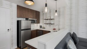 Uma cozinha moderna com eletrodomésticos de aço inoxidável, armários de madeira e iluminação pendente.