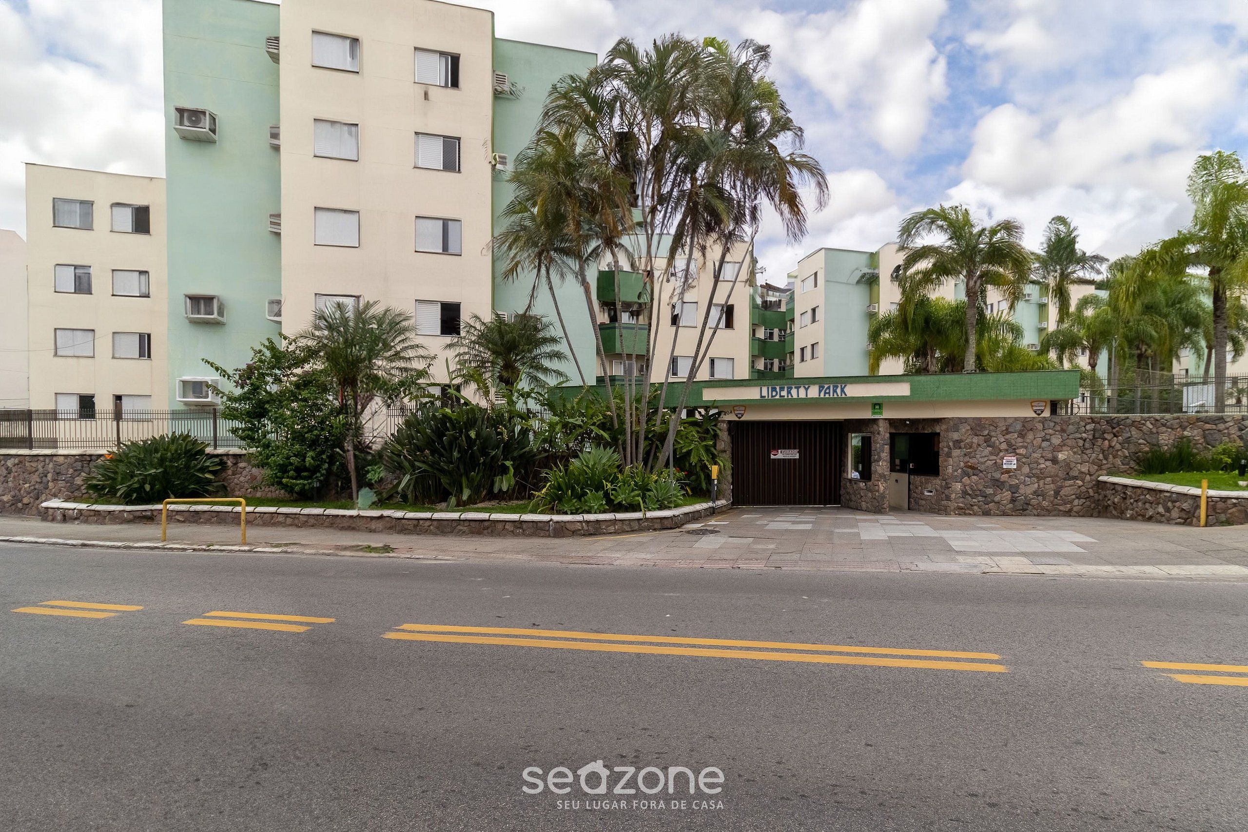 Edifício de vários andares com entrada verde identificada como 
